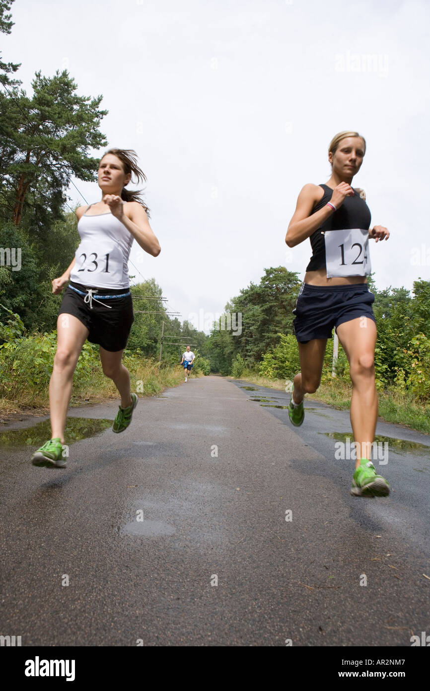 Two women running on road in sports race Stock Photo - Alamy