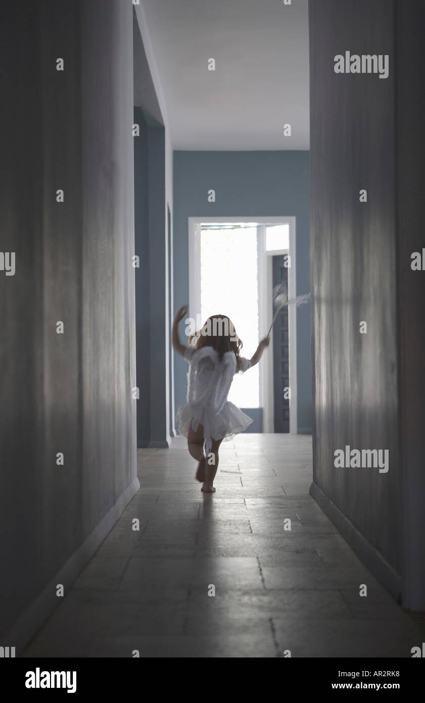 Girl dressed as fairy running along corridor Stock Photo - Alamy