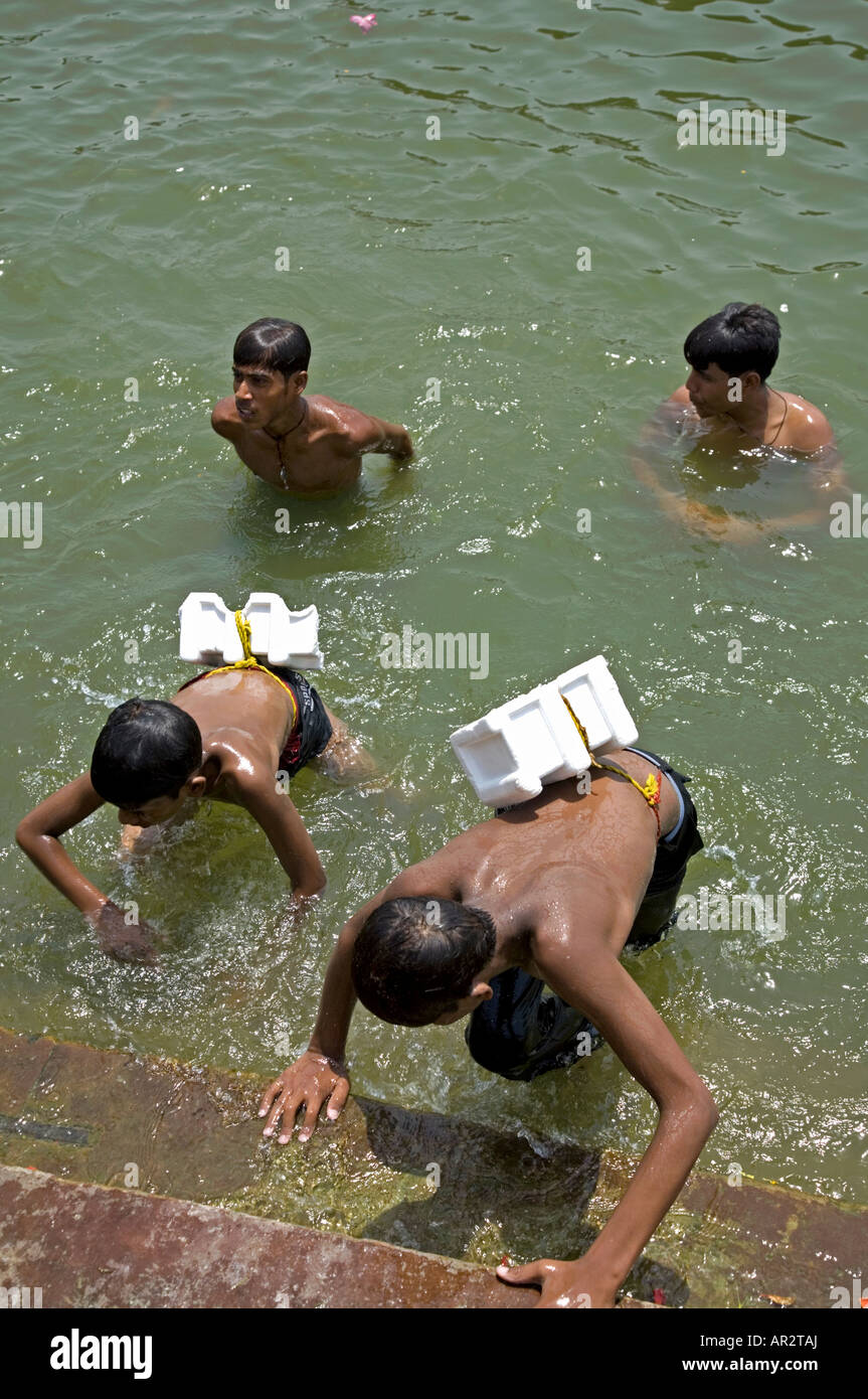 Boys swimming with a peculiar lifebelt. Hanuman Ghat. Ganges river ...