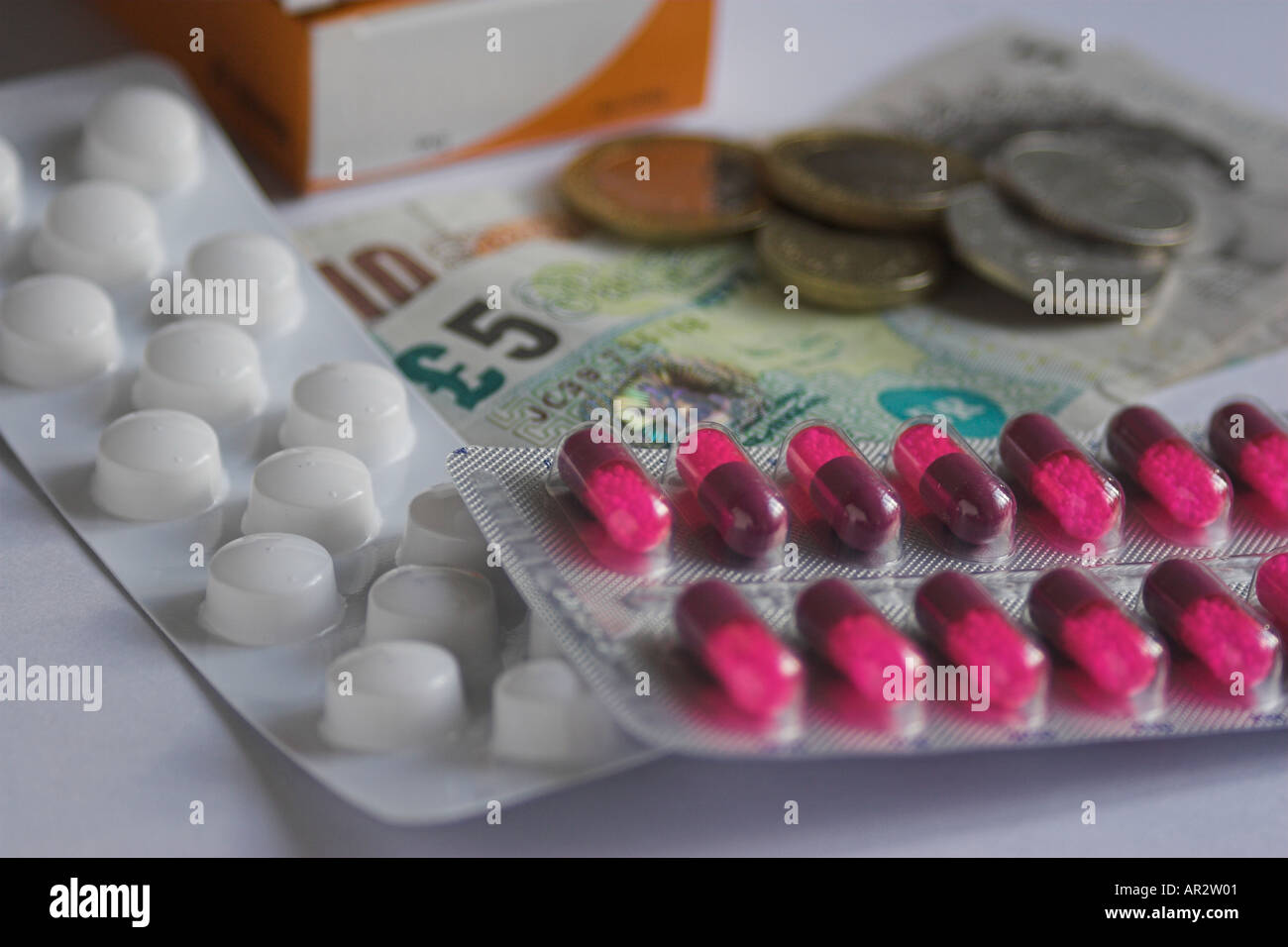 Concept image showing tablets / pills / capsules and money (sterling ...
