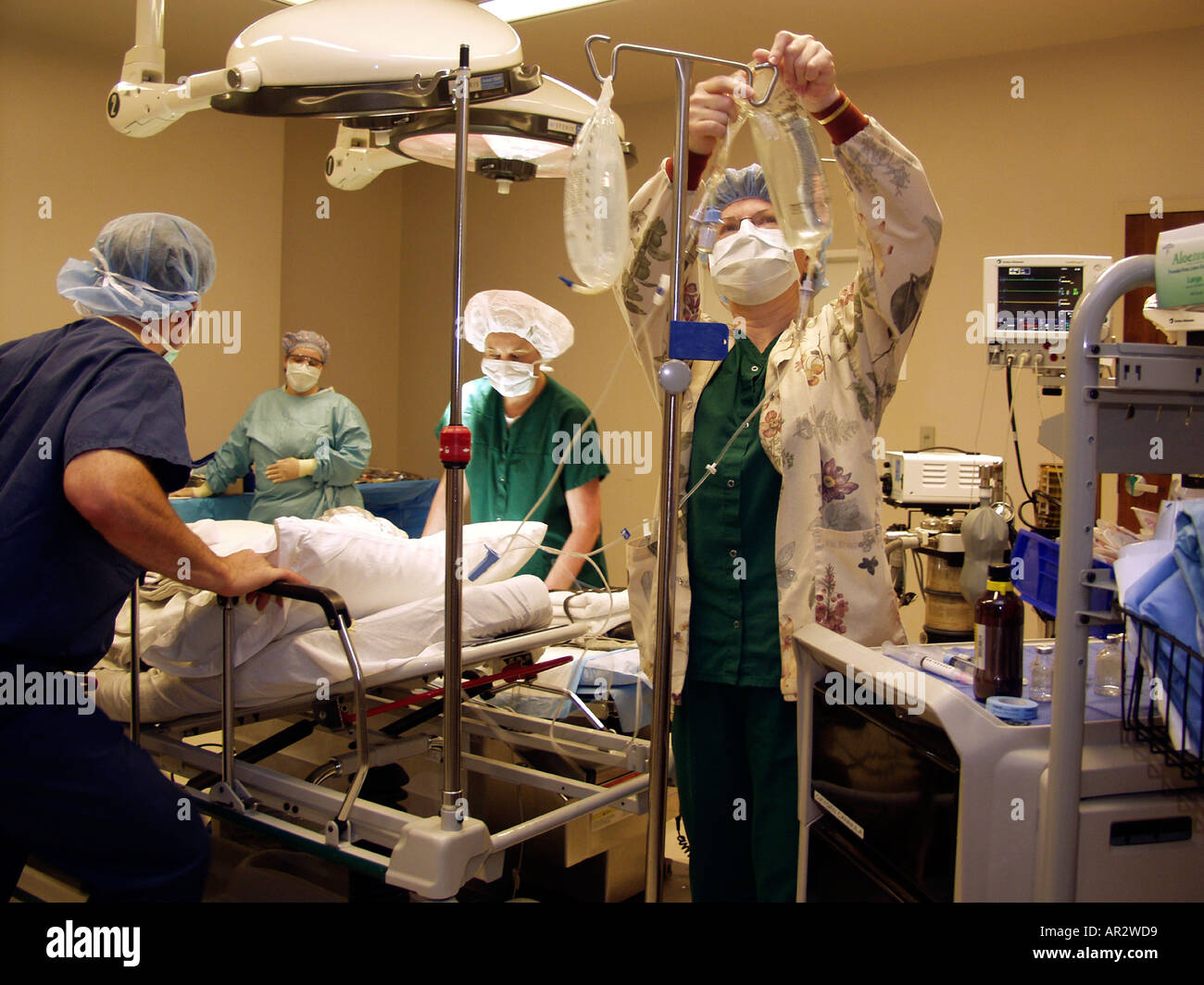 Doctors and nurses preparing to move patient to operating room table ...
