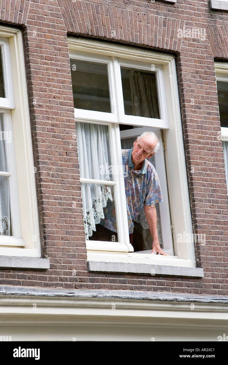 HOLLAND AMSTERDAM MAN LOOKING AND LEANING OUT OF THE OPEN WINDOW OF HIS ...