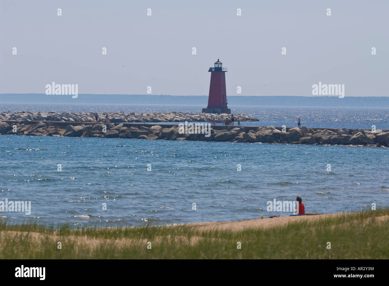 Lighthouse and tourists at the Lake Michigan beach at Manistique ...