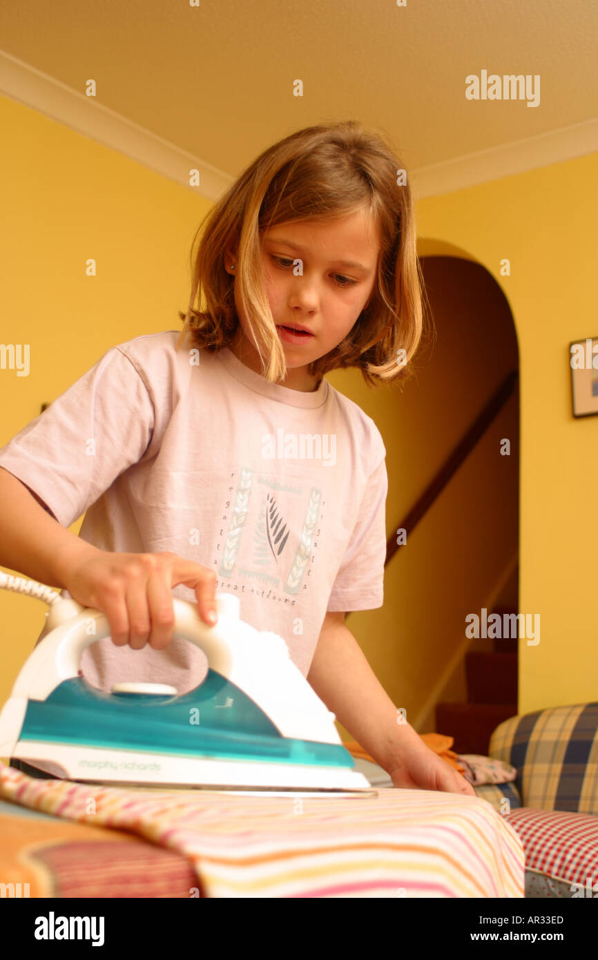 Young girl aged 11 years old learning to iron clothes Stock Photo - Alamy