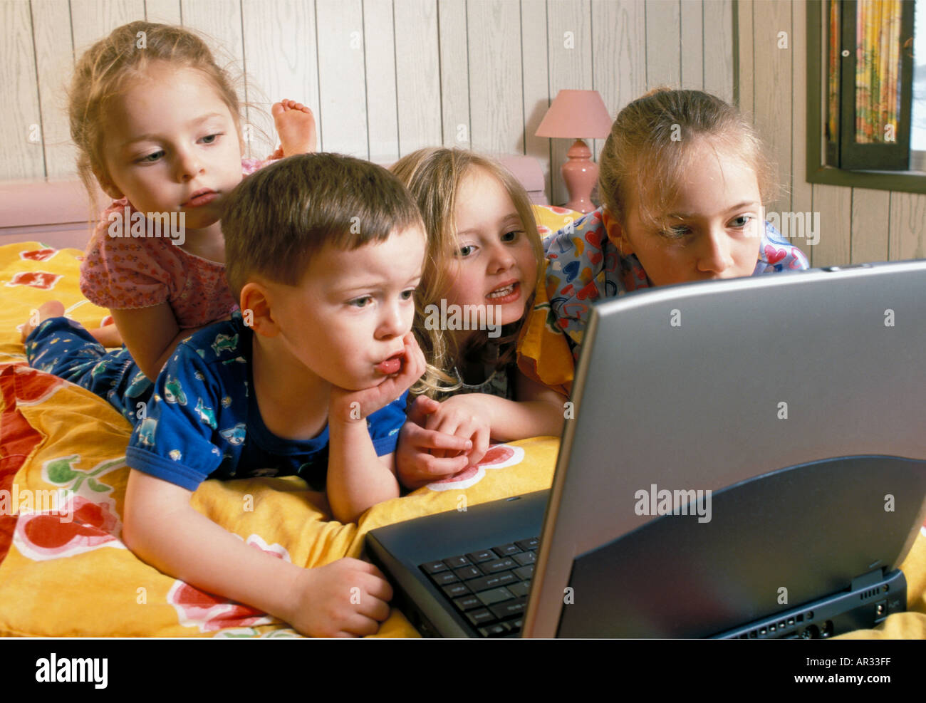 Laptop 4 kids looking at laptop in bedroom Stock Photo - Alamy