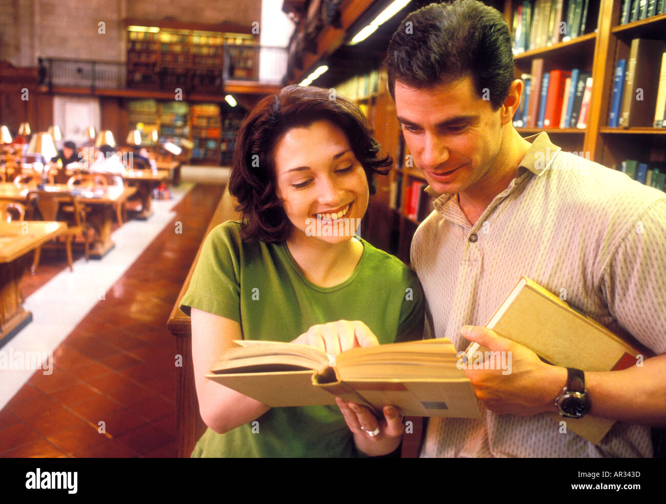 Public Library Couple reading book Stock Photo - Alamy