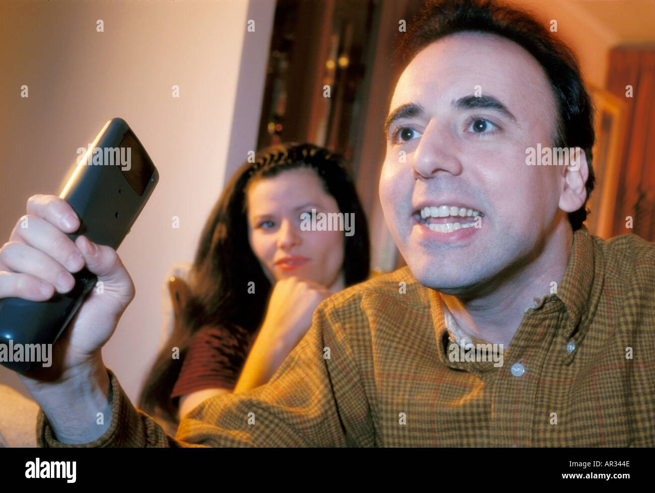 Remote control Man watching enthusiastically TV Stock Photo - Alamy