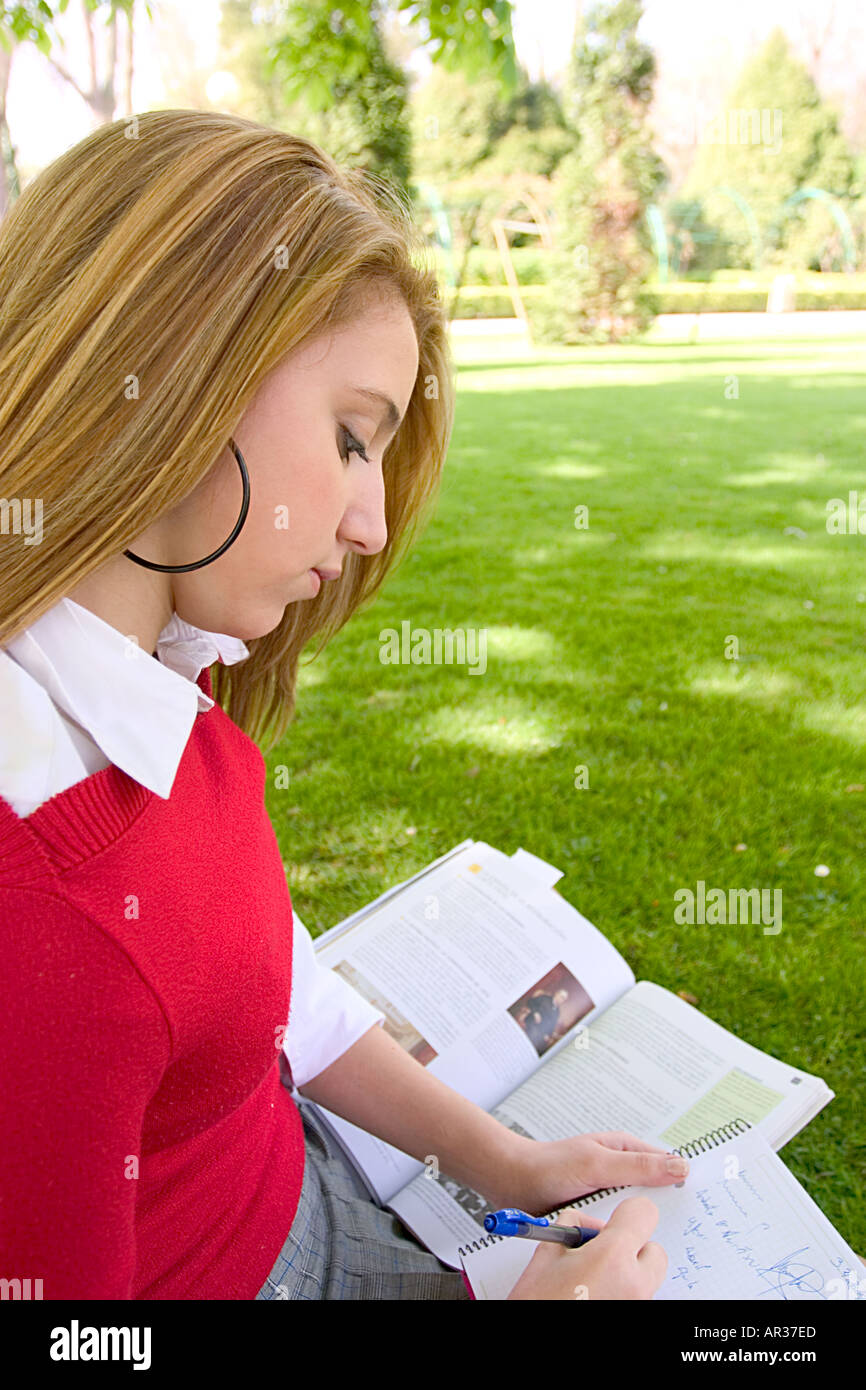 Teenage blonde schoolgirl studying in the park Stock Photo - Alamy