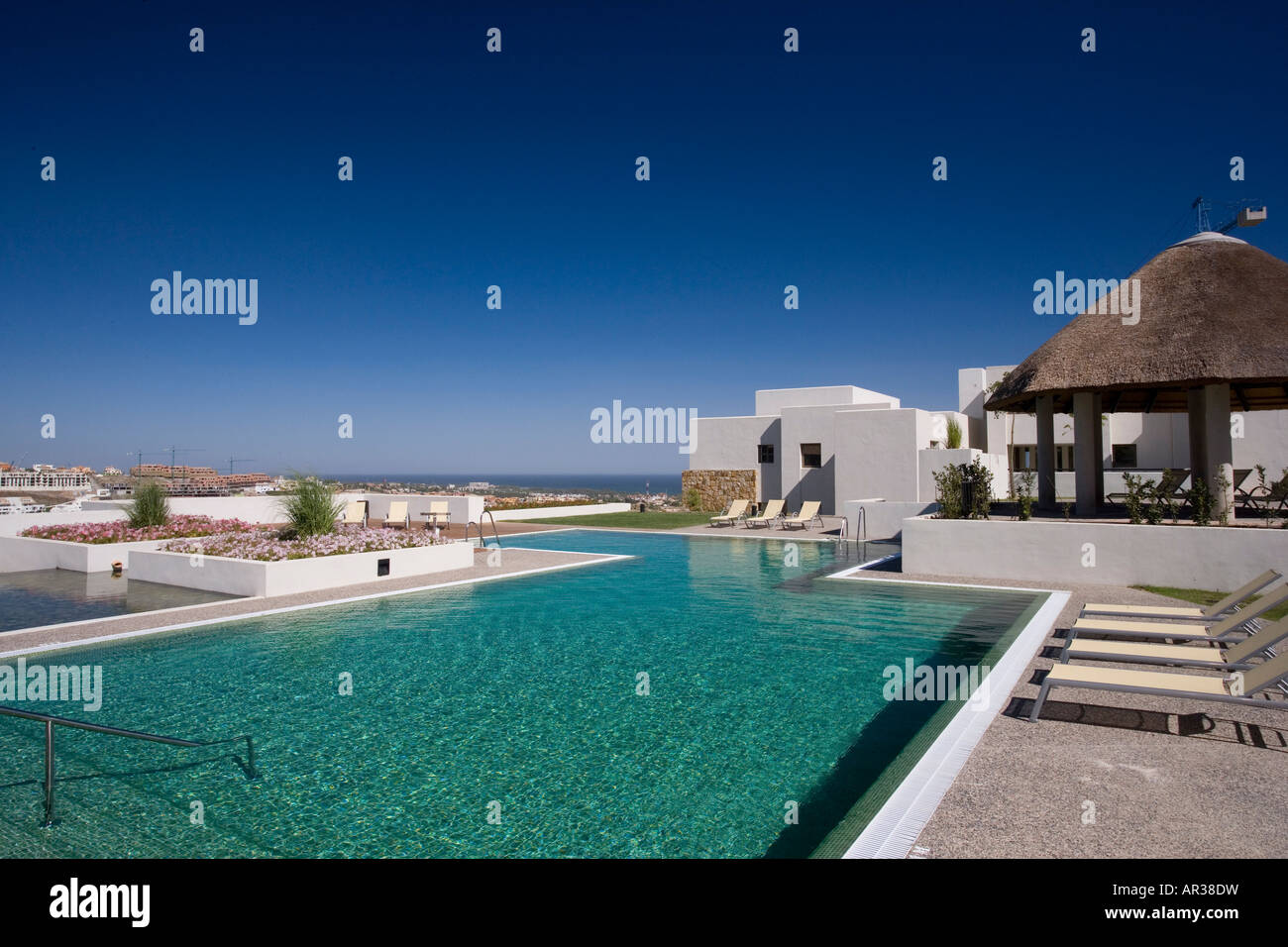 Green swimming pool and blue sky on summer day with white modern ...