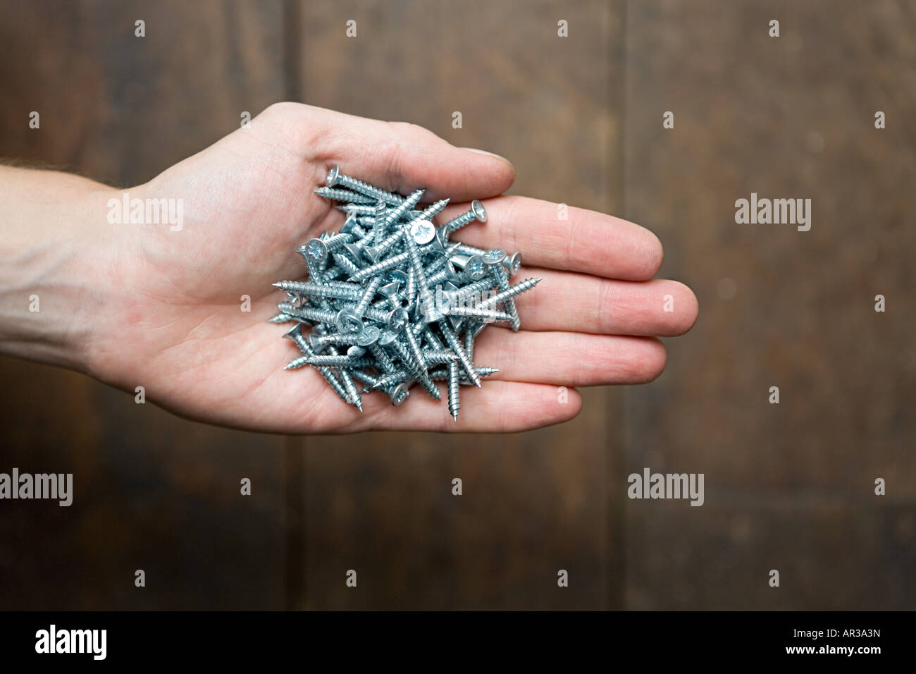 Person with screws in hand Stock Photo - Alamy