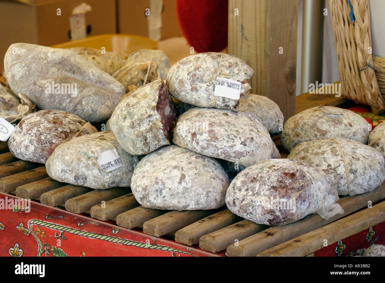 Selection of meats saucissons and sausages on market stall on slatted ...