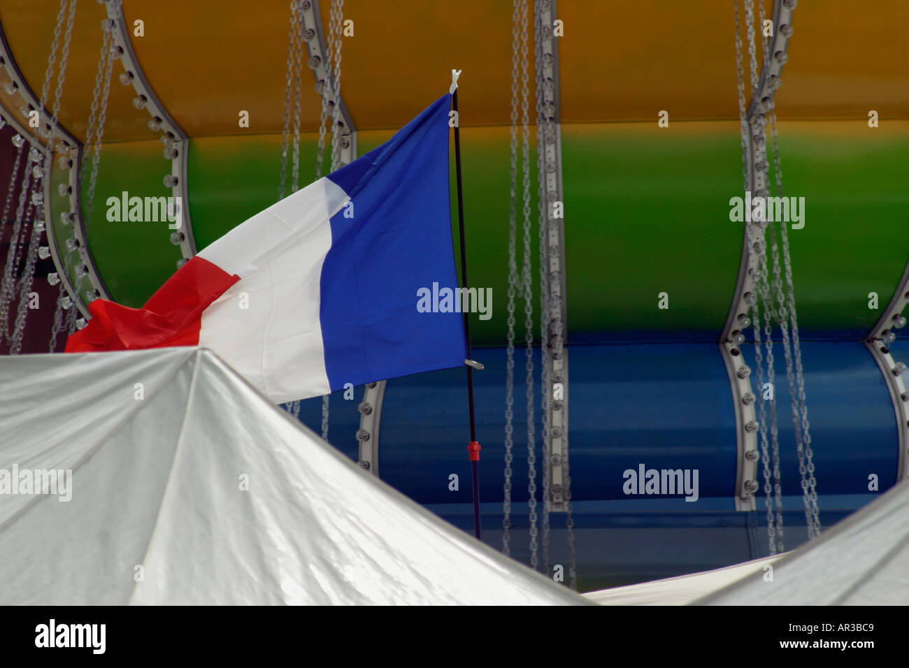 French flag at market with flying chair ride in background Stock Photo ...