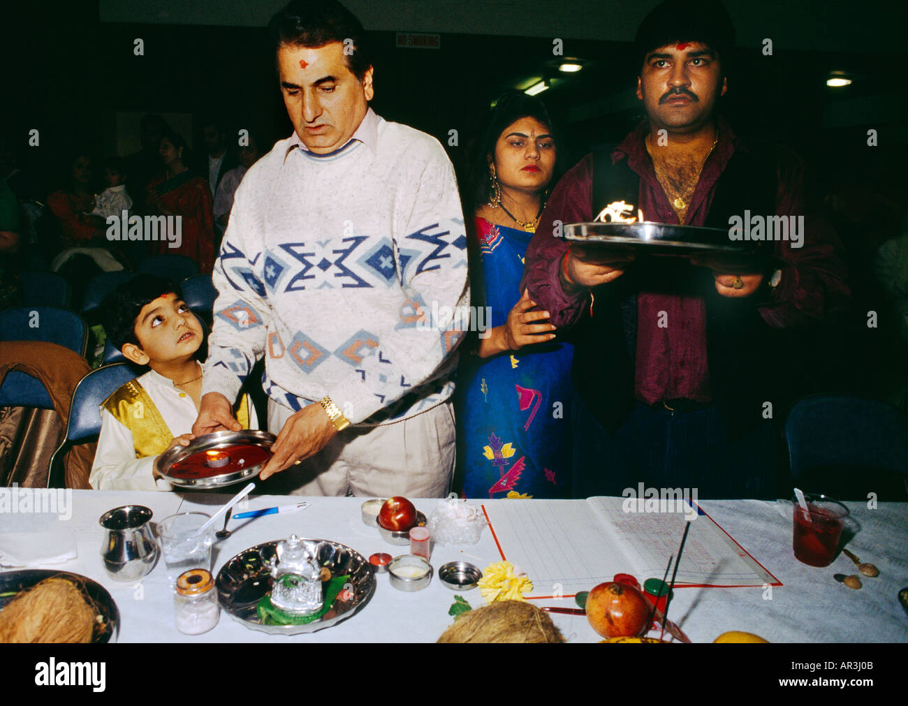 Family Holding Diya over Red Chopdis Performing Chopda Puja During ...