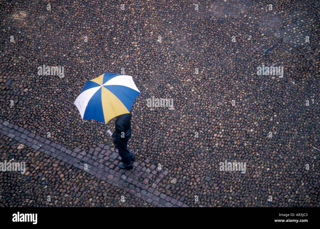 Man walking in rain with umbrella Stock Photo - Alamy