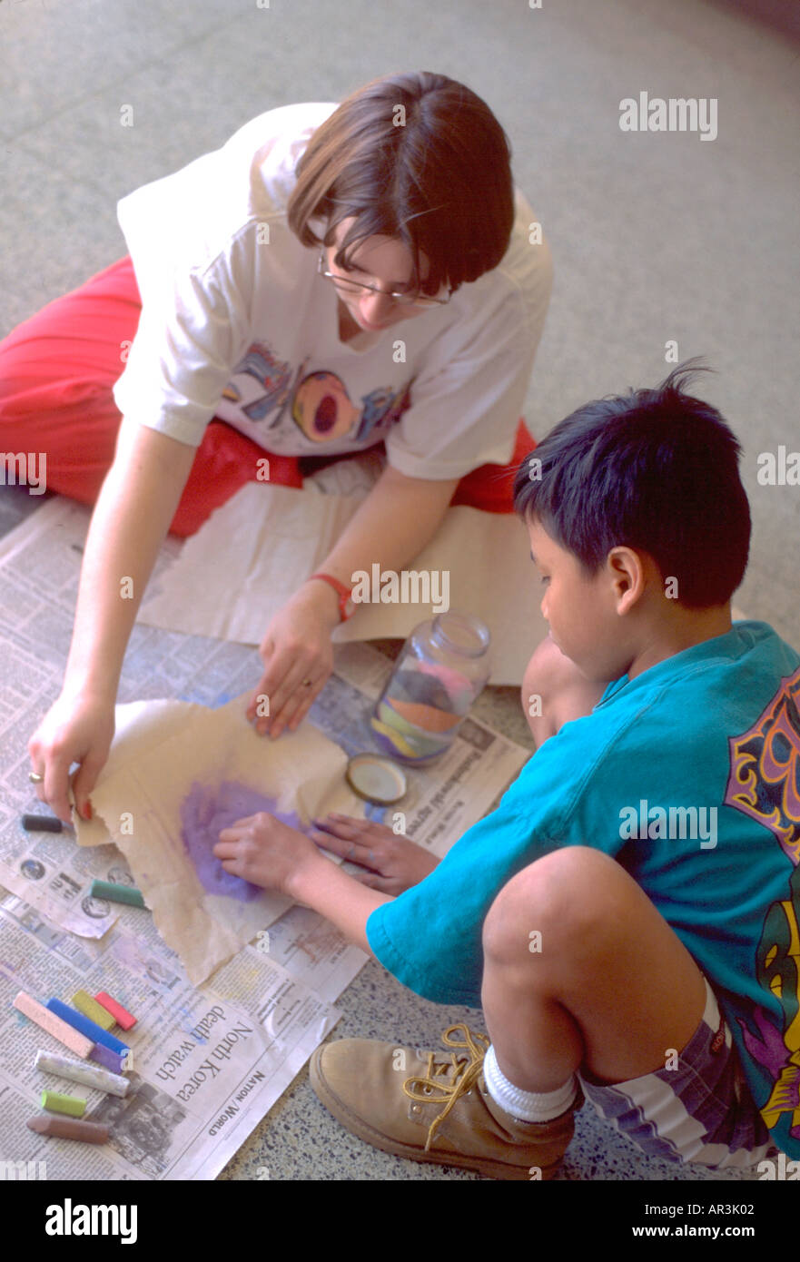 Asian student age 8 and teacher age 20 with sand art project in after ...