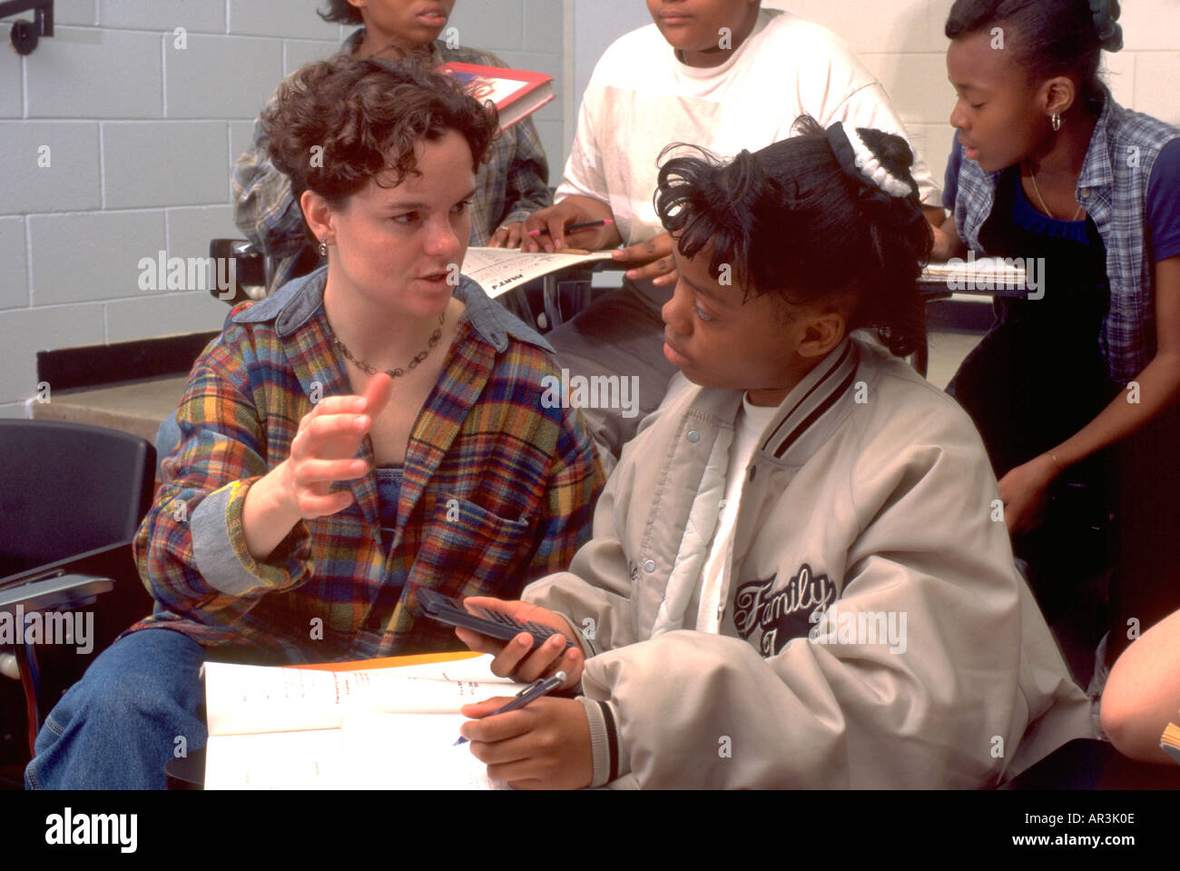 Tutor age 21 with African American students age 12 discussing studies ...