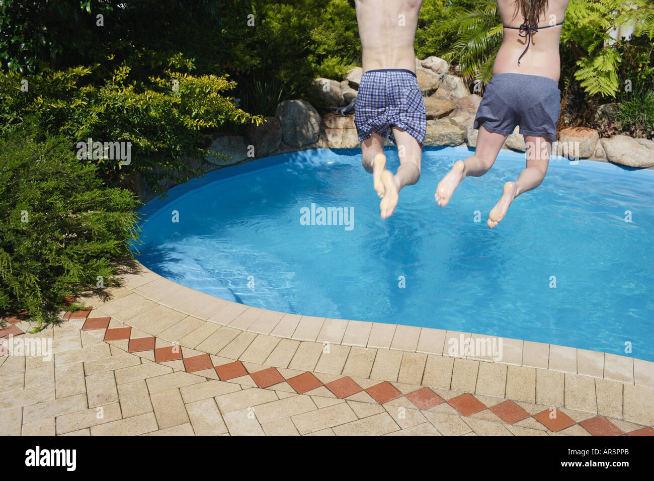 Couple jumping into pool hi-res stock photography and images - Alamy
