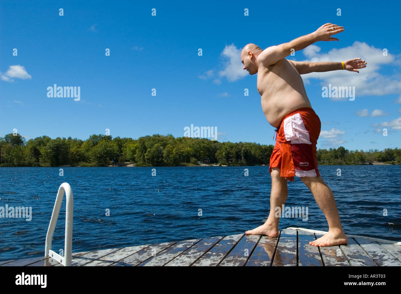 man diving off dock on summer day Stock Photo - Alamy