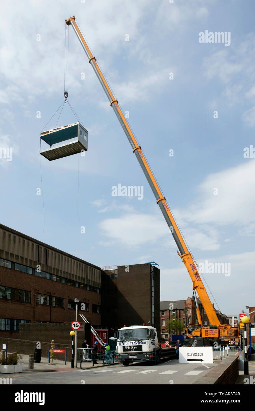 LARGE INDUSTRIAL CRANE LIFTING PORTABLE BUILDING Stock Photo - Alamy