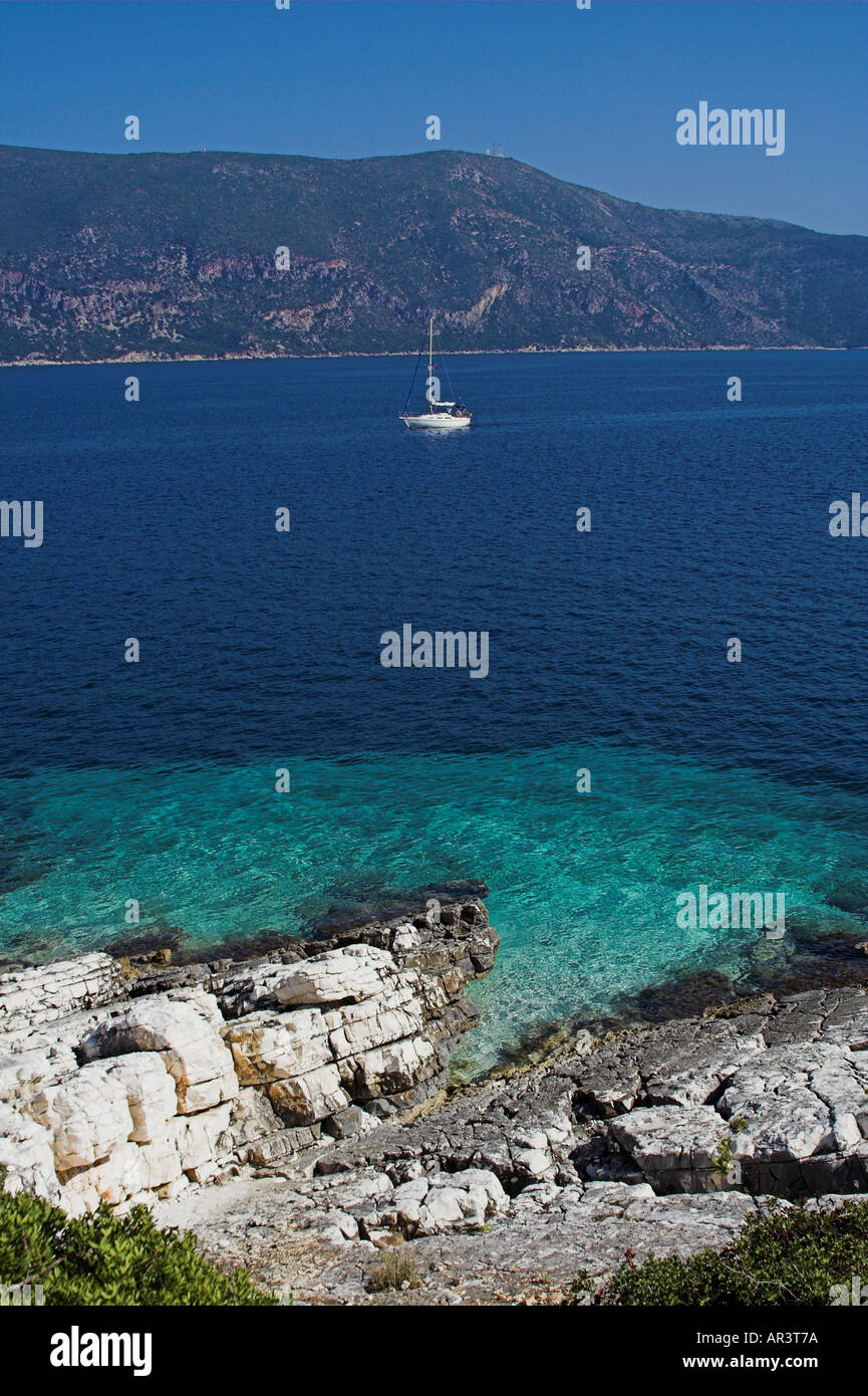 Boat at Sea with Rocks Stock Photo - Alamy