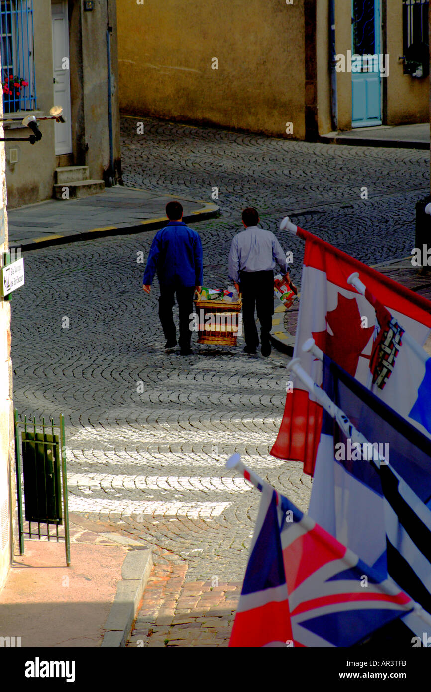 Two men carrying a heavy basket Stock Photo - Alamy