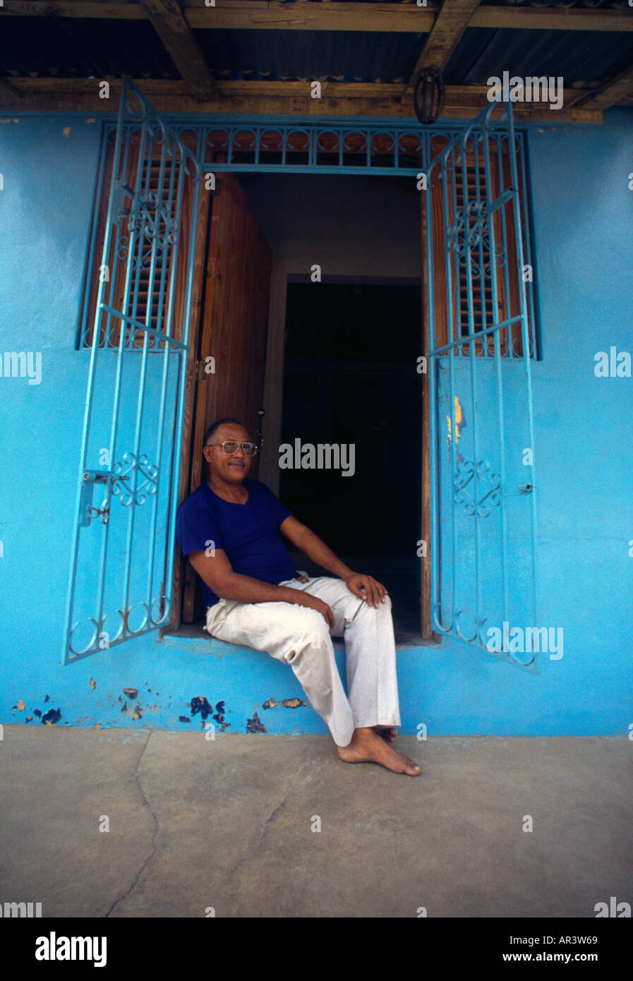 Dominican Republic Los Charamicos Man Sitting In Doorway Stock Photo ...