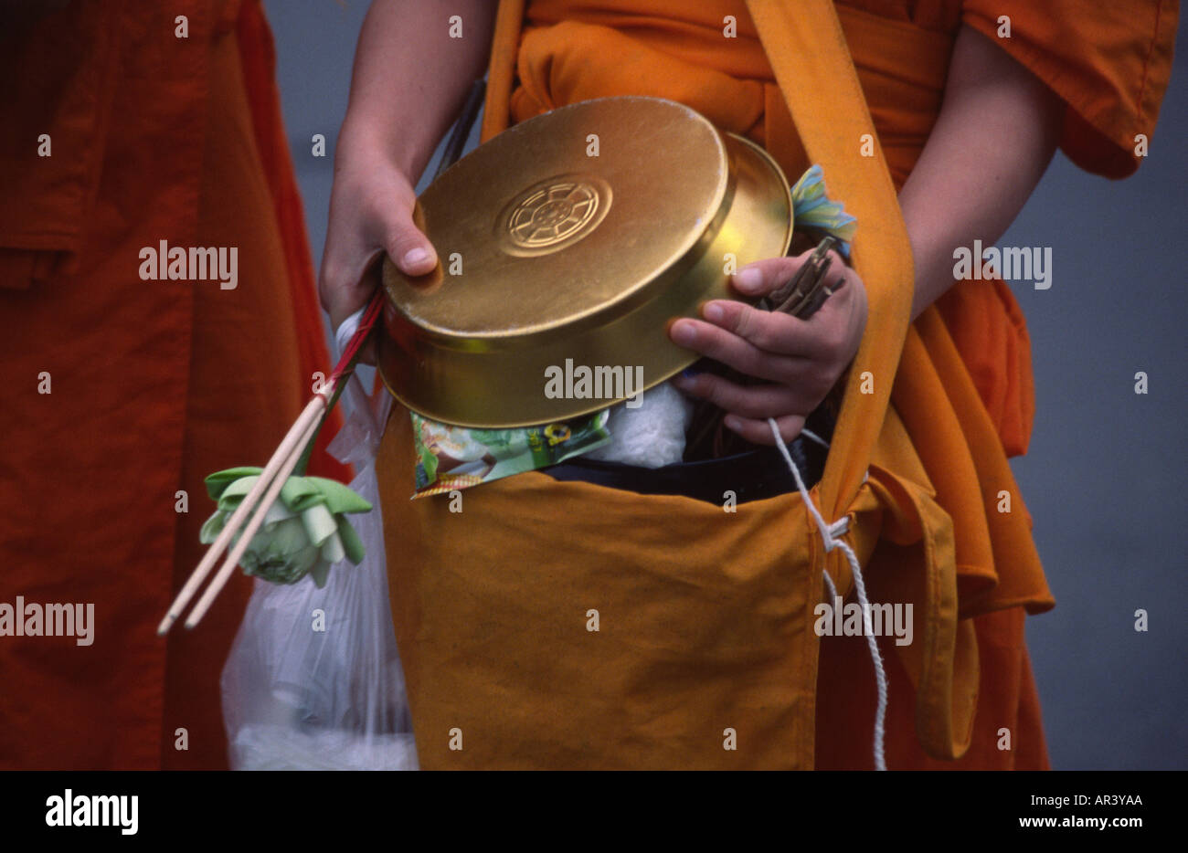 Buddhist monk holds gifts given during a street collection, Chiang Mai ...