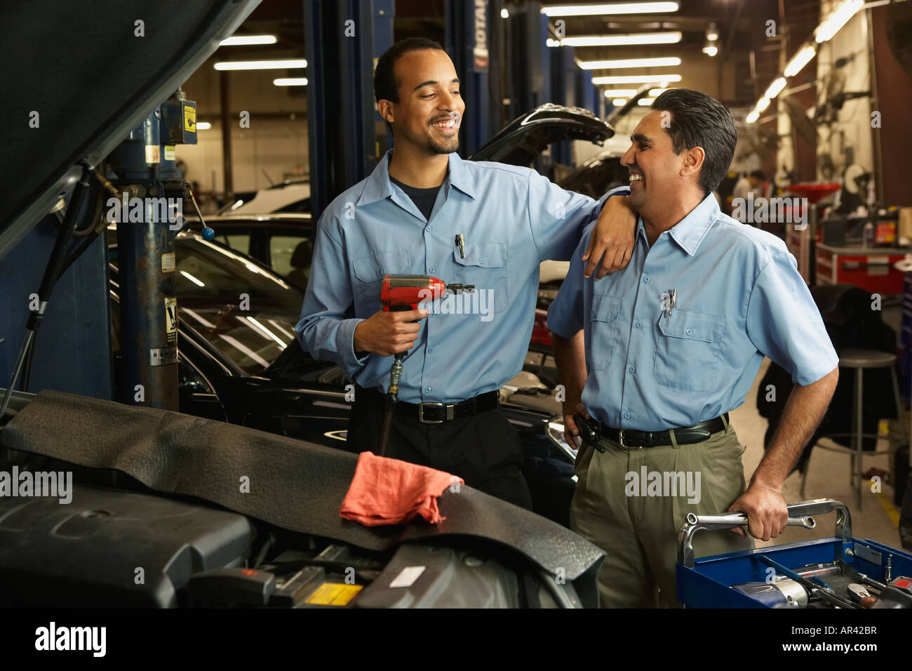 Multi-ethnic male auto mechanics in shop Stock Photo - Alamy