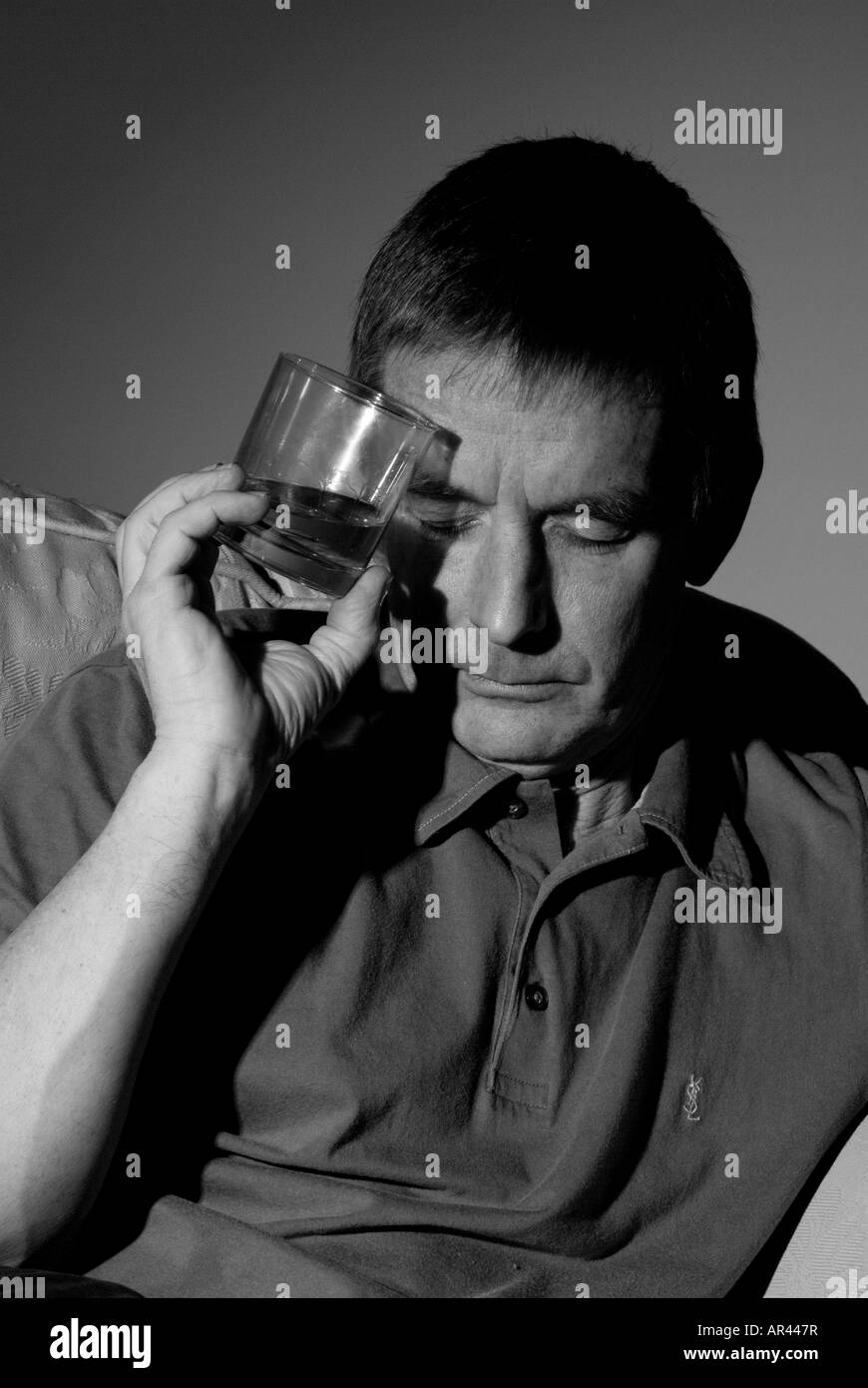 worried man sitting on sofa with drink stressed man Stock Photo - Alamy