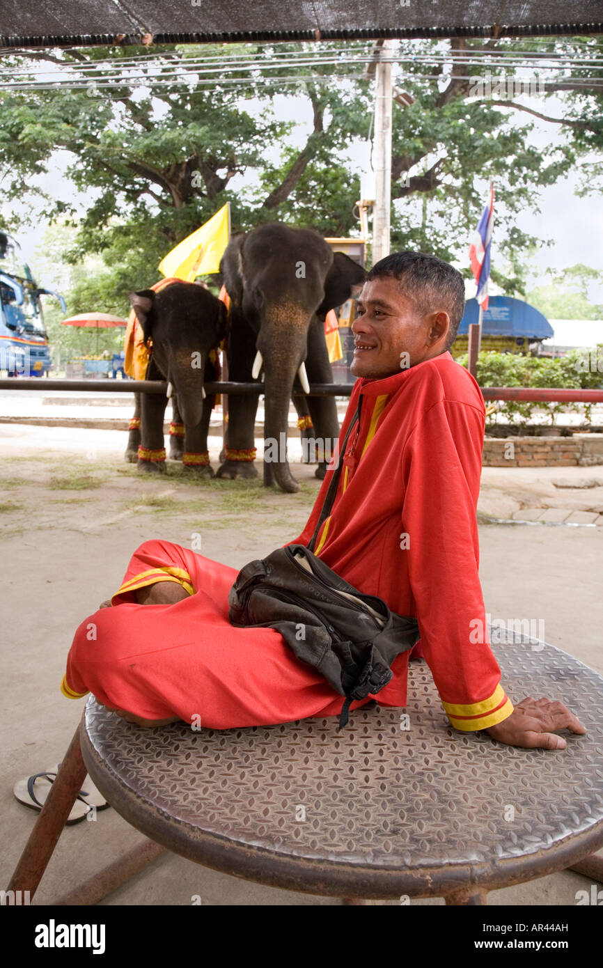 Elephant mahoot (keeper) rests between giving rides to tourists in ...