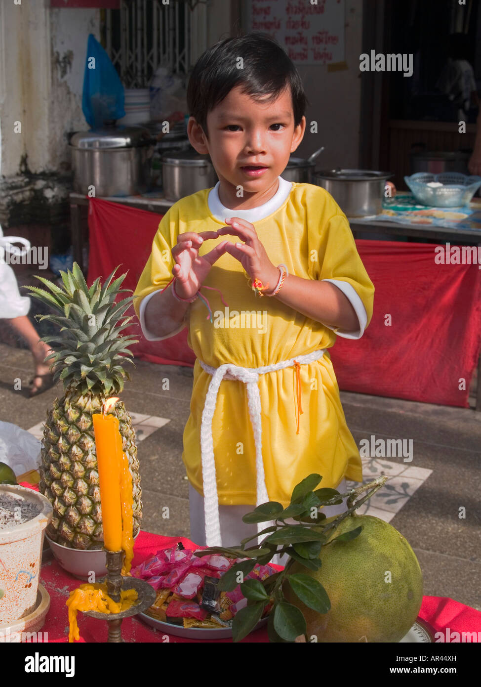 a young boy prepares to salute spirit deities at the bizarre Vegetarian ...