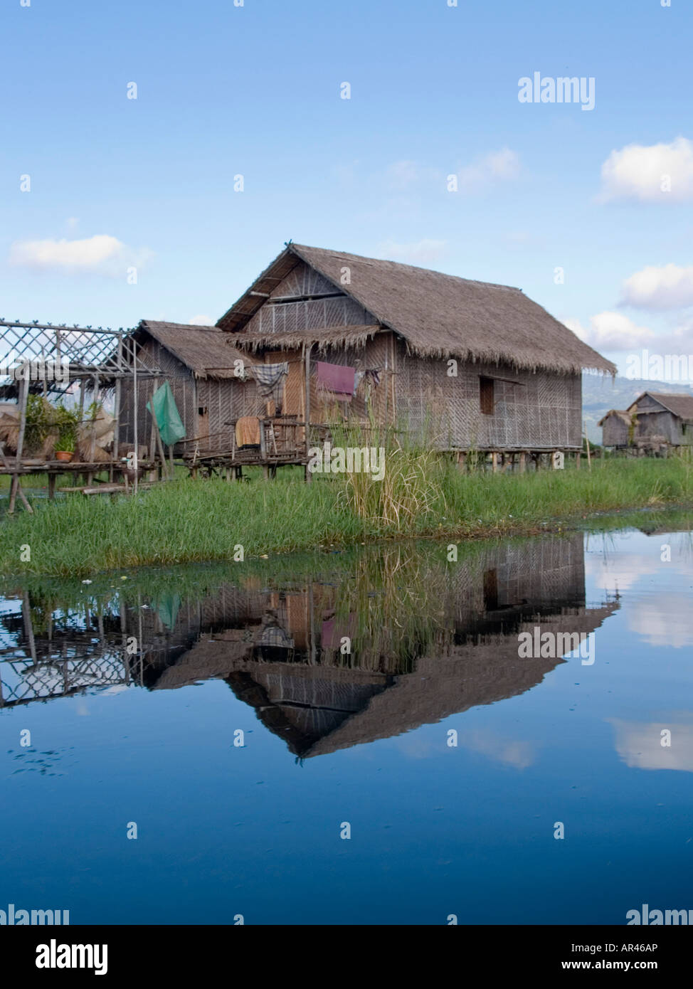 reflection of a traditional bamboo house on Inle Lake in Myanmar Stock ...