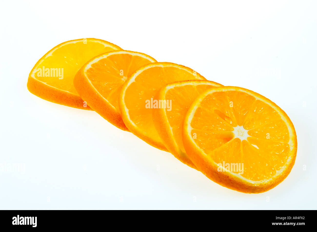 white background shot of an orange sliced into sections with the ...