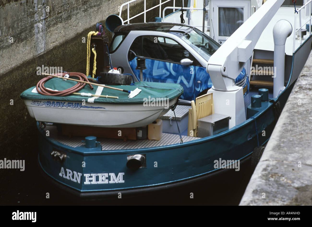 Boat carrying small car and rowing boat going through canal lock at ...
