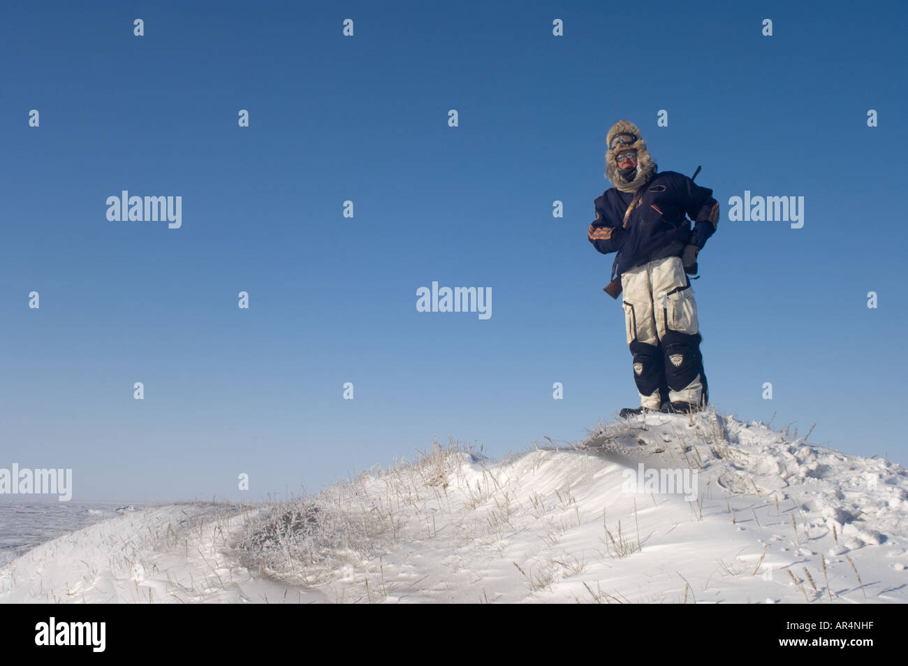 inupiat hunter scouts the landscape for wildlife along the Arctic coast ...