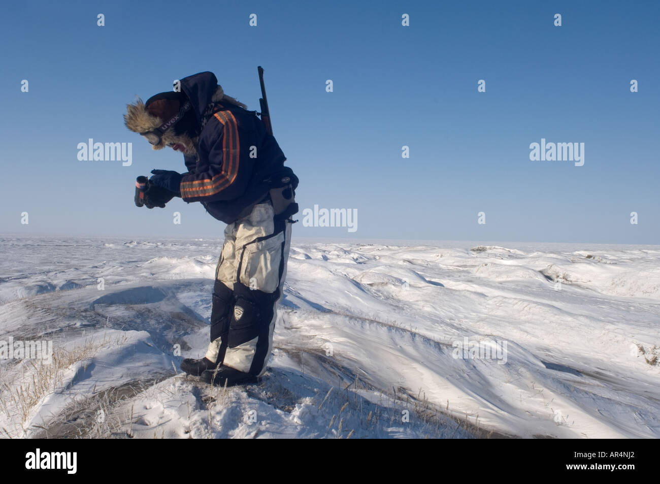 inupiat hunter scouts the landscape for wildlife along the Arctic coast ...