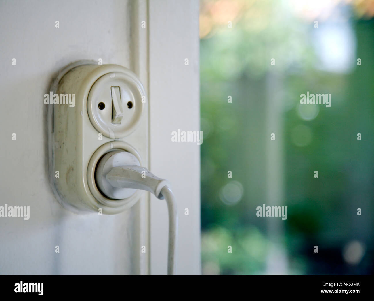 Close up of old fashioned plug socket and plug against out of focus ...