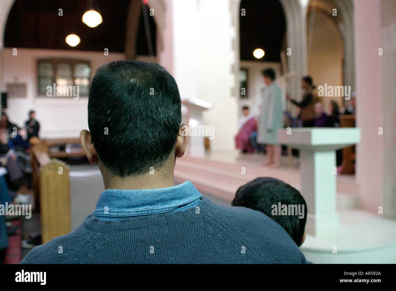 Back of father s head sitting next to child at Catholic church near ...