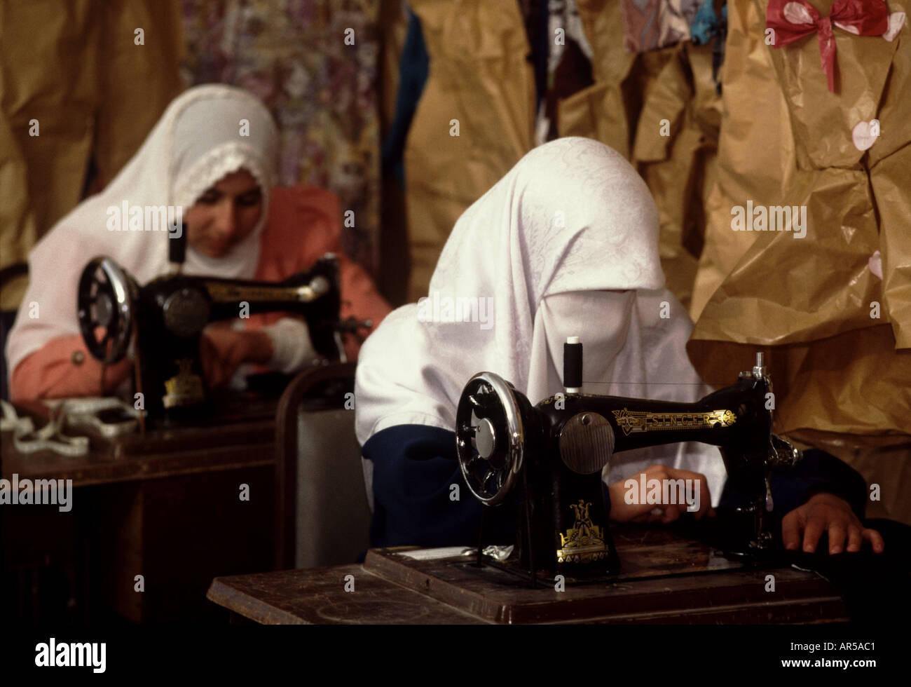 Jordanian women with heads covered and some veiled work on sewing ...