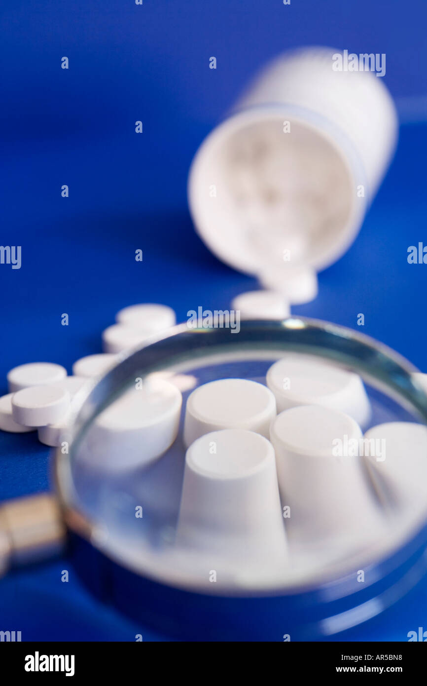 magnifying glass and pills Stock Photo - Alamy