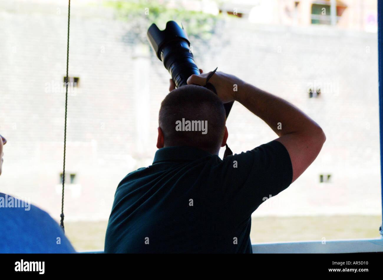 A photographer with a large lens shooting upward Stock Photo - Alamy