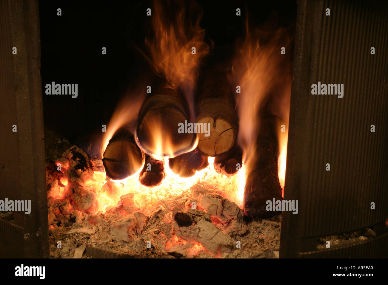 Logs alight in a wood burning stove Stock Photo - Alamy