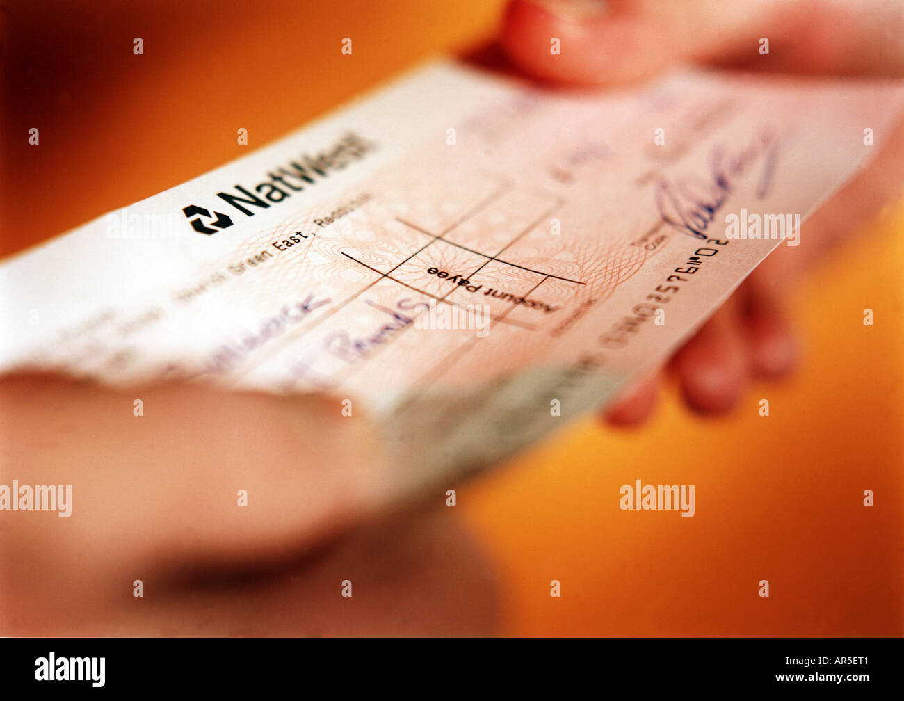 A portrait of someone paying someone else a cheque drawn on the NatWest ...