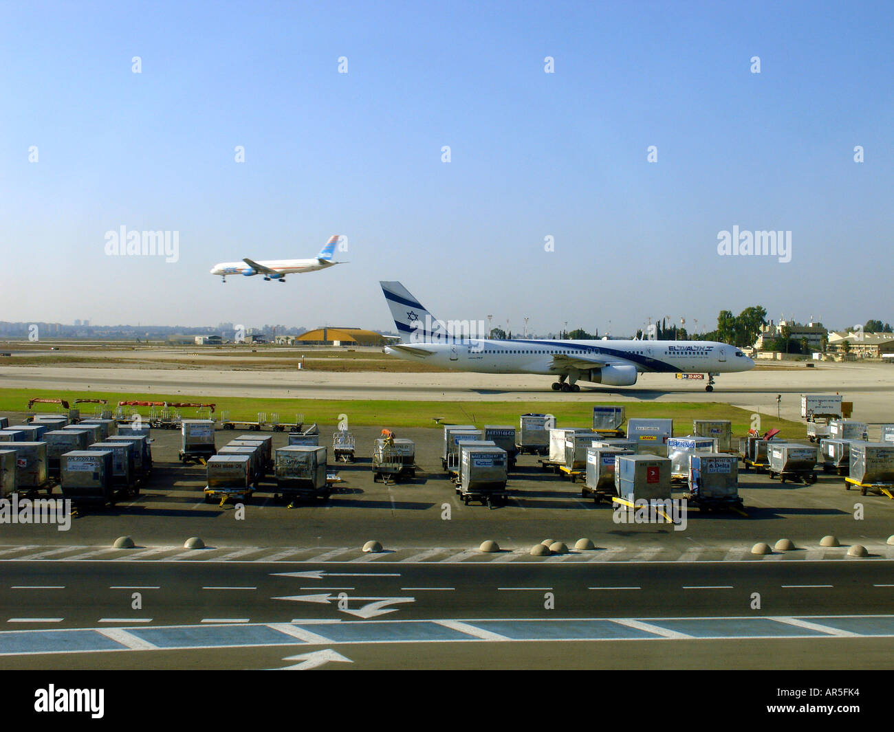 Cargo trailers with Boeing 737 airplane of El Al airline at the tarmac ...
