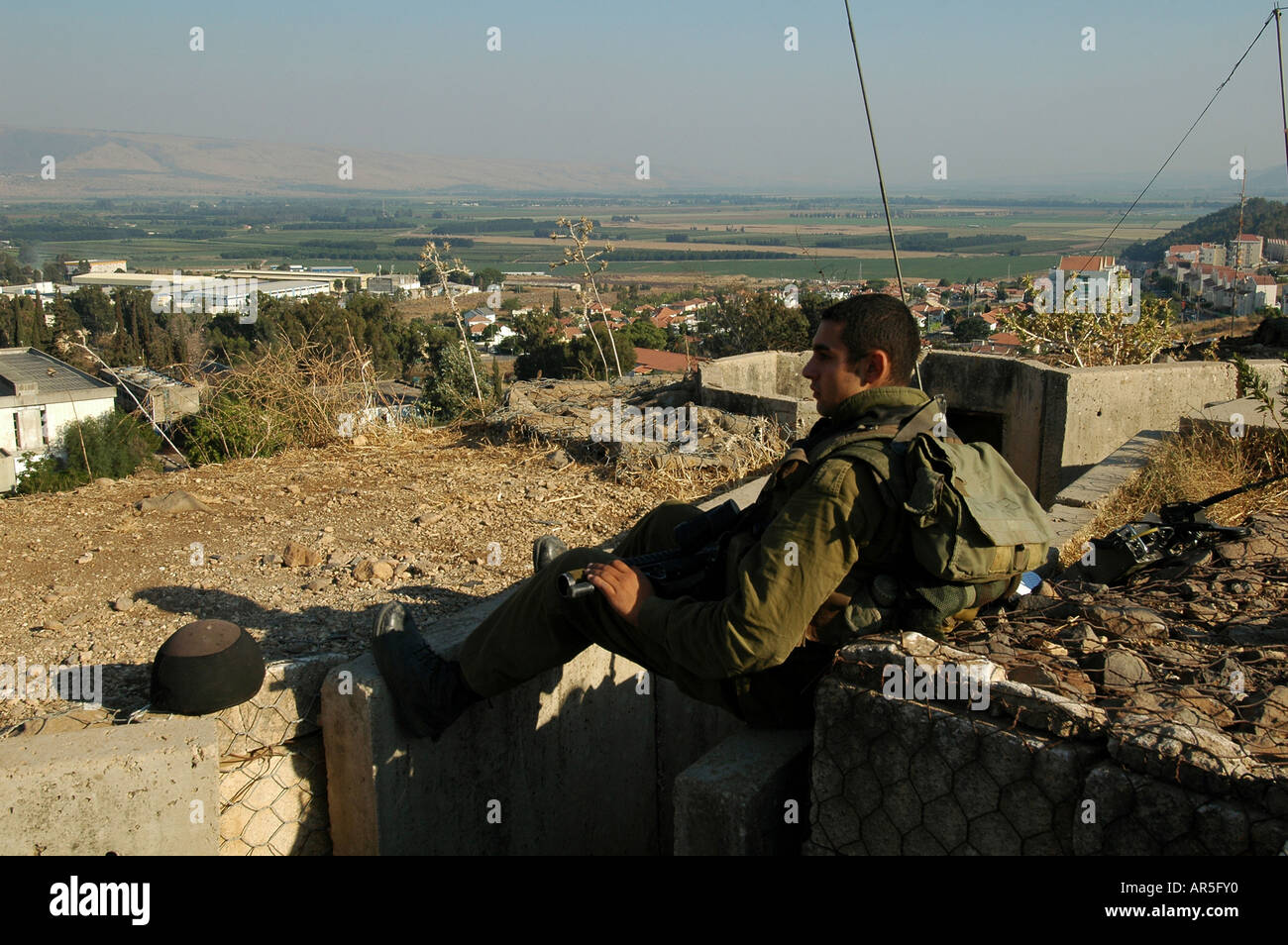 An Israeli soldiers stands in a military outpost overlooking the ...