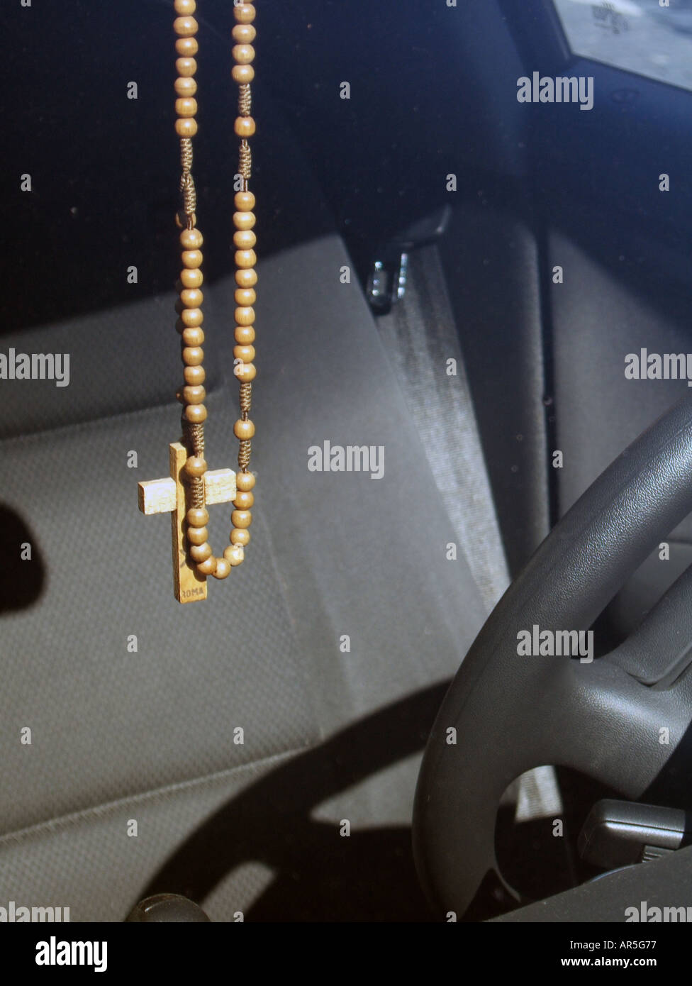 christian cross rosary hanging in car window Stock Photo - Alamy