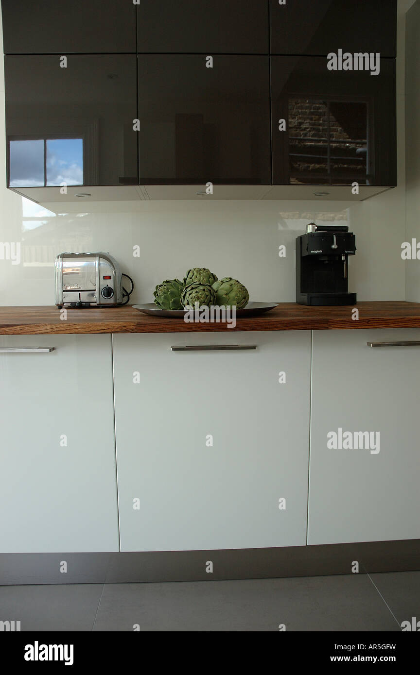 Coffee machine and stainless steel toaster on worktop of modern kitchen ...