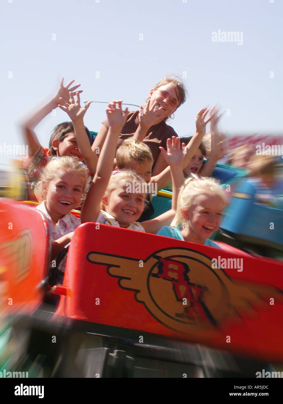 Children enjoying ride on roller coaster at carnival Stock Photo - Alamy