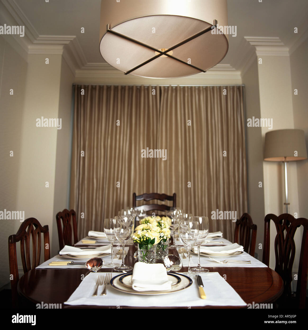 White placemats and plates on antique table in modern dining room with ...