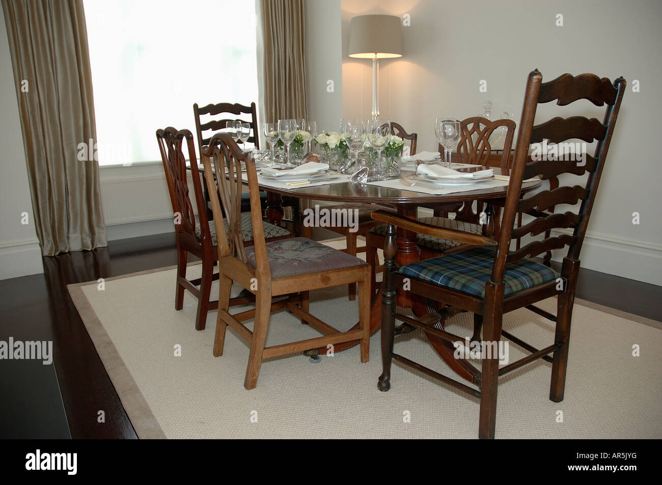 Traditional table and chairs in modern dining room with cream rug Stock ...